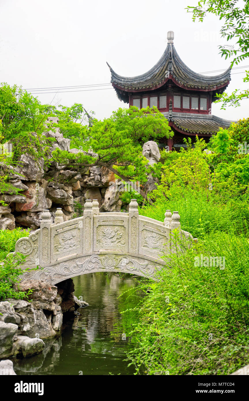 A arched stone bridge with the classical Chinese li yuan garden in ...
