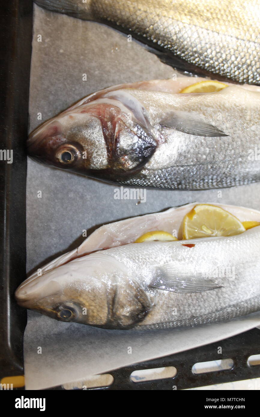 Raw sea bass stuffed with lemon Stock Photo - Alamy