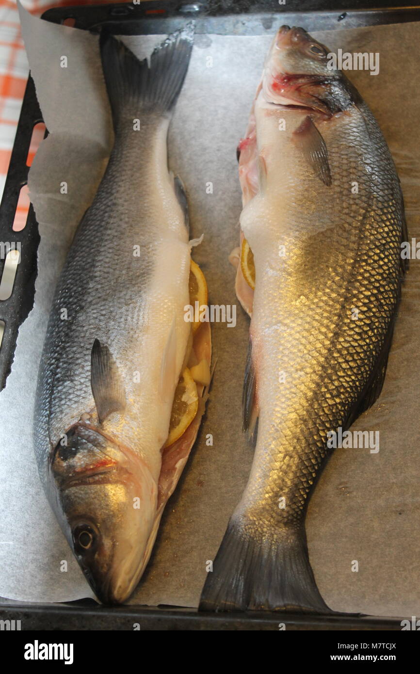 Raw sea bass stuffed with lemon Stock Photo - Alamy