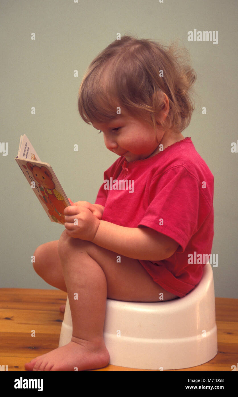 little girl sitting on potty reading Stock Photo - Alamy