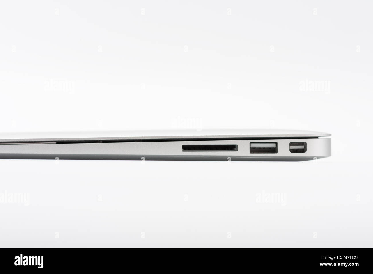 Part of closed modern new laptop with ports on white background, close ...