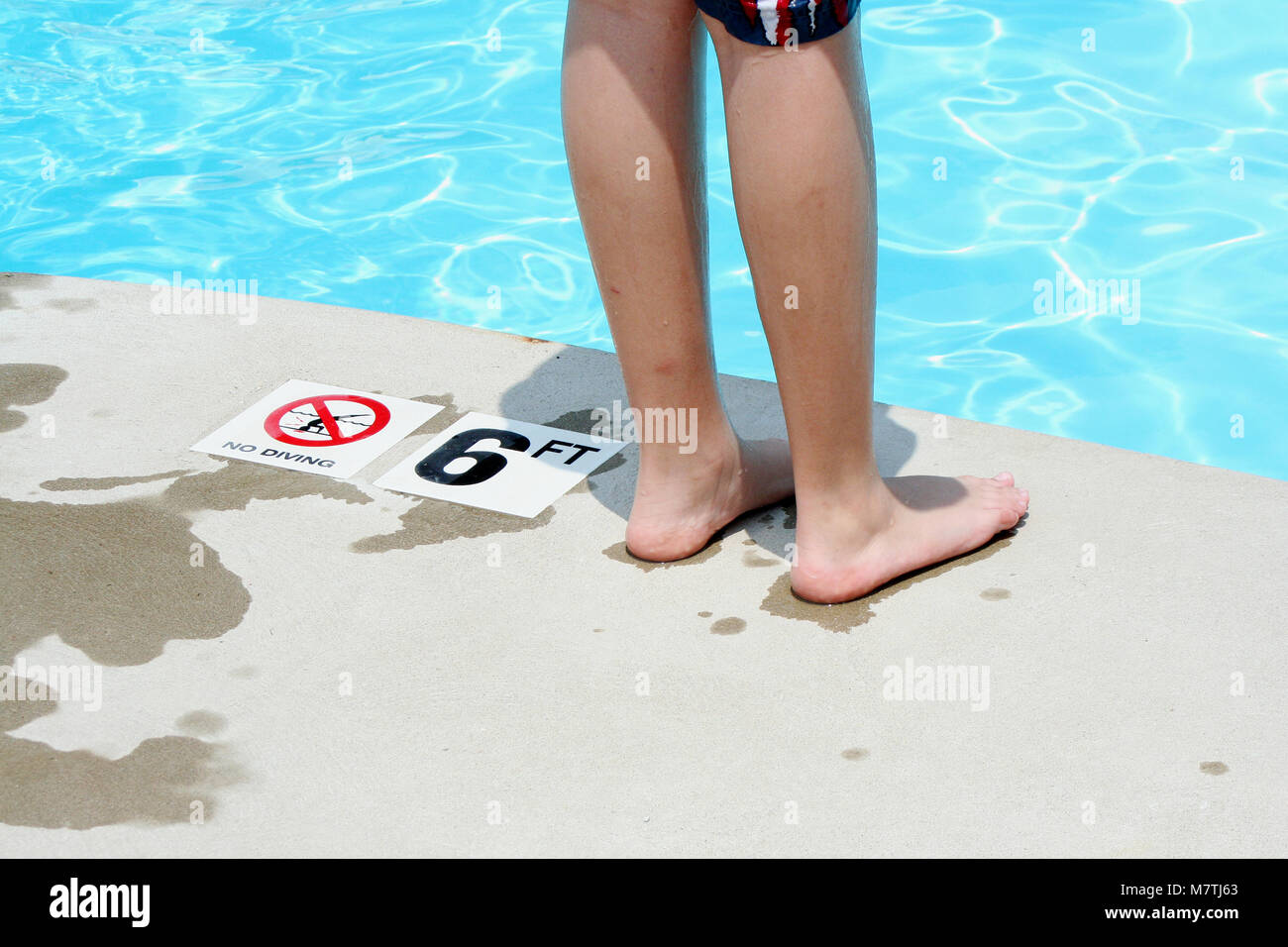 A Teenage boy standing by a swimming pool Stock Photo - Alamy