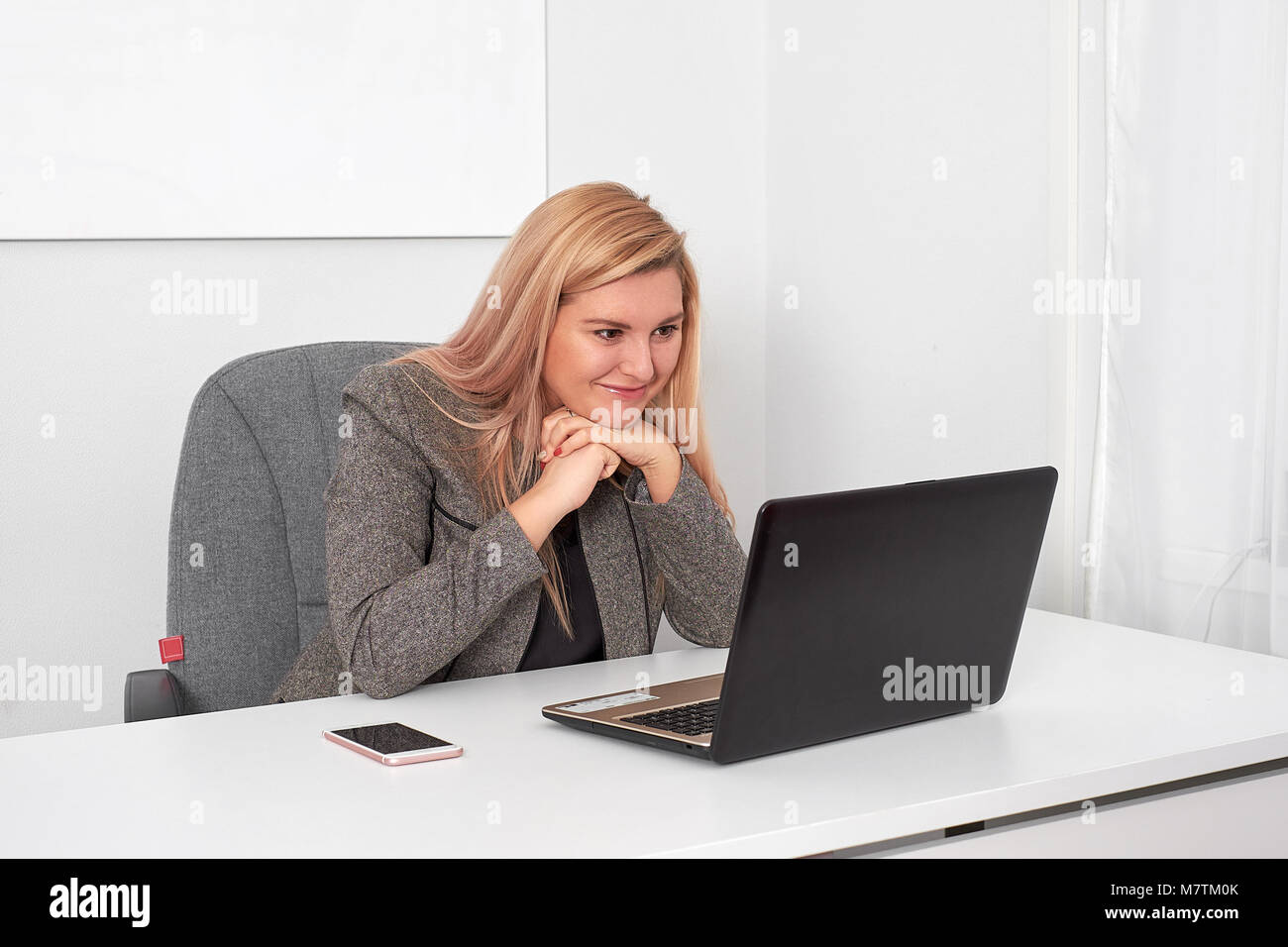 Beautiful business woman is working behind laptop at office Stock Photo ...