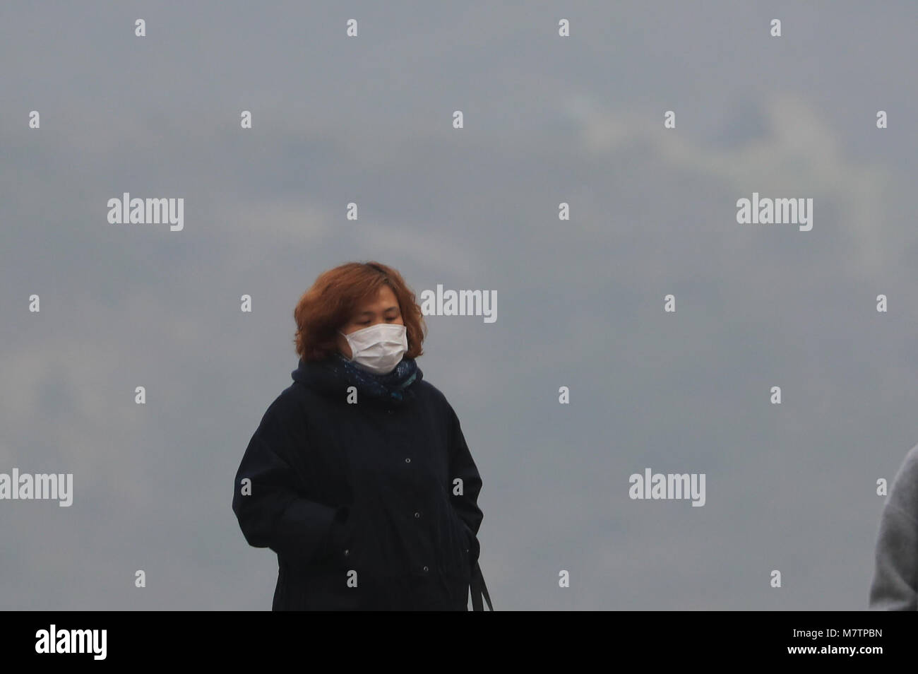Hazy again from fine dust A woman walks through downtown Seoul wearing ...