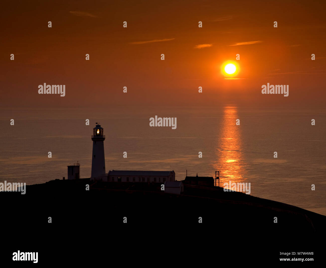 South Stack lighthouse at sunset, Anglesey, North Wales with sun ...