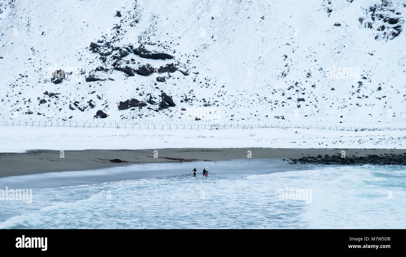 Brave surfers in the freezing cold Lofoten Island during winter, Norway ...