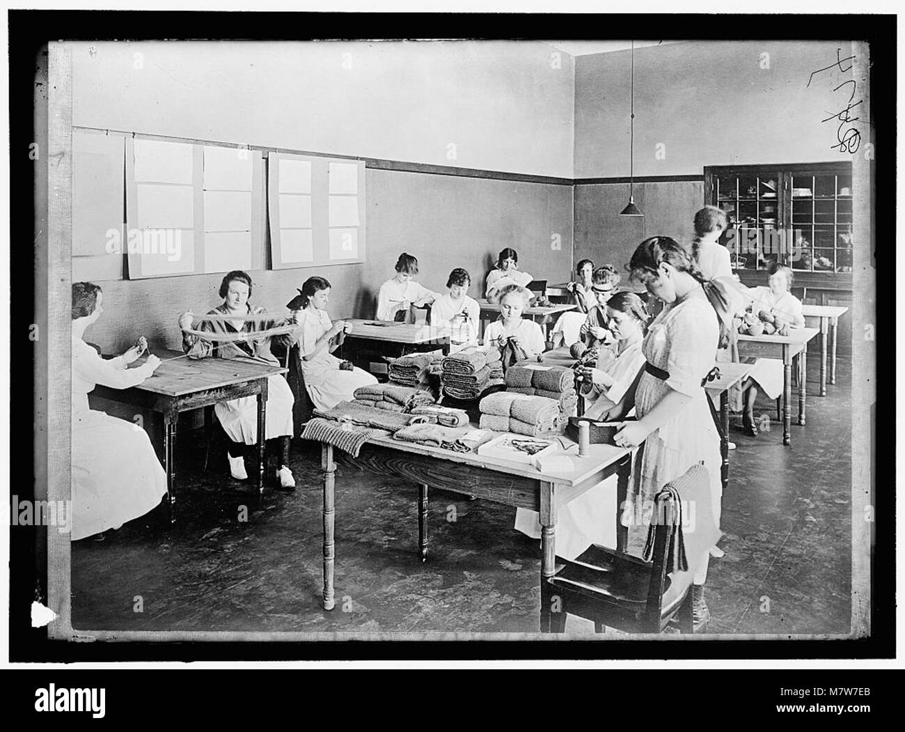 The image showcases women working in the Red Cross Garment Division ...