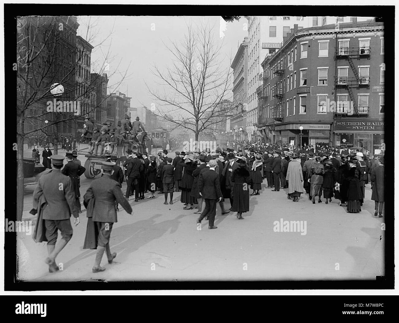 U.S. soldiers traveling through a city in trucks and automobiles ...