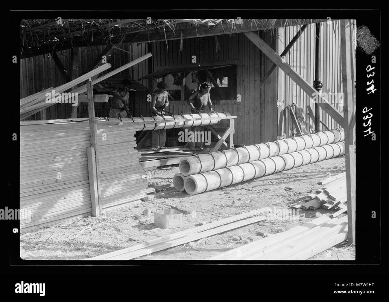 A historical photograph documenting the construction of wooden pipes ...