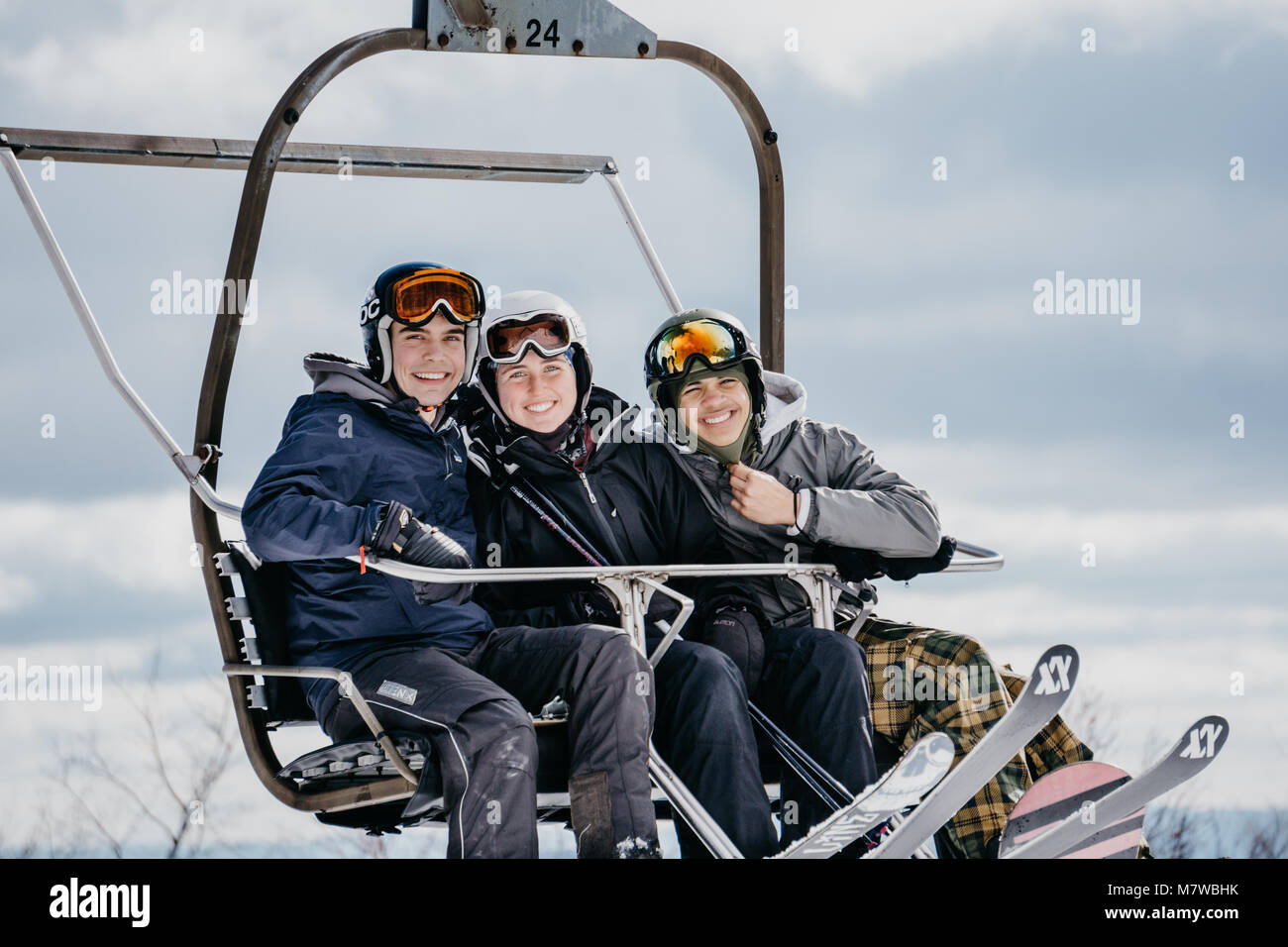 Three skiers on a chair lift Stock Photo - Alamy