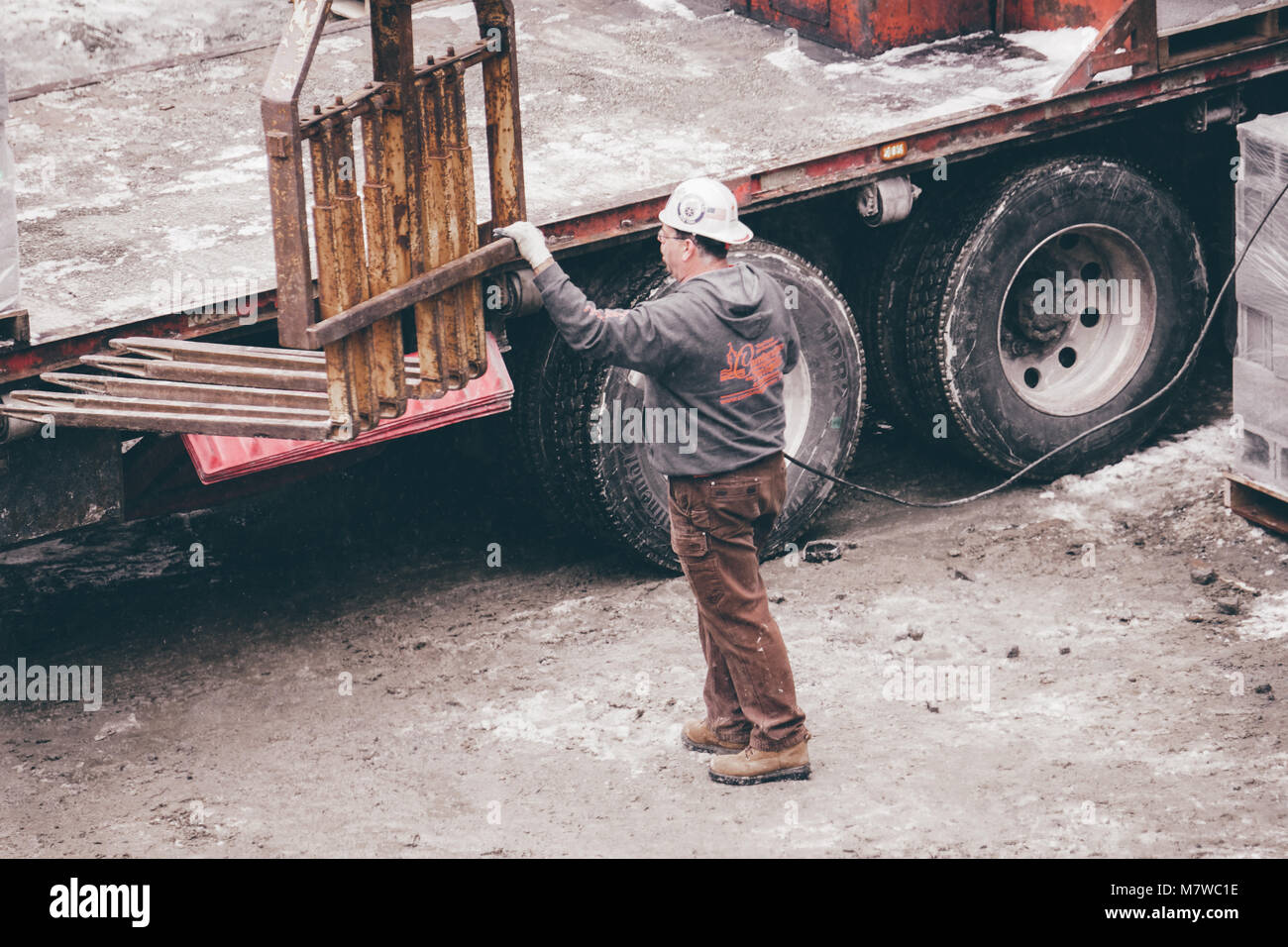 Construction worker with trailer and pallets Stock Photo - Alamy