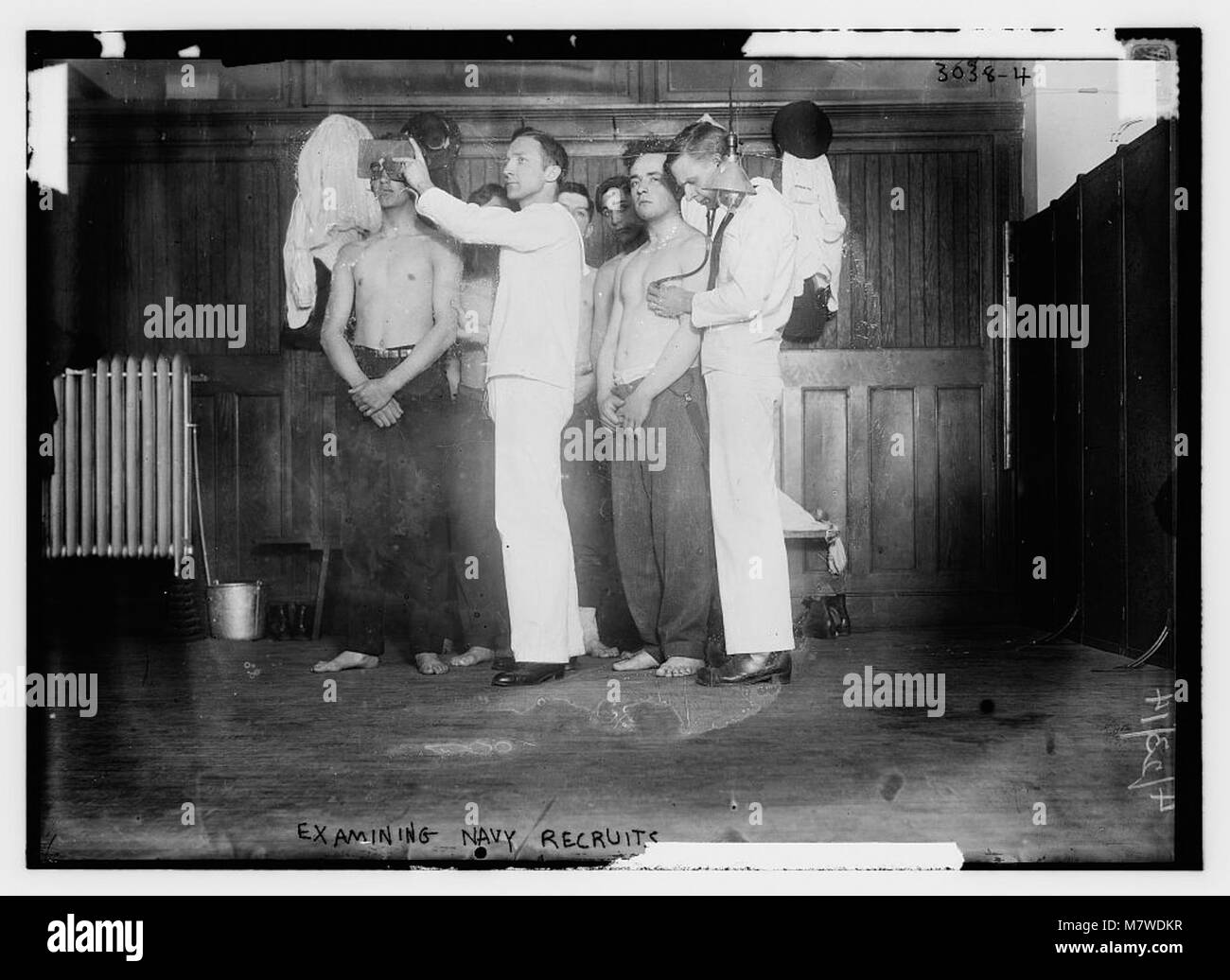 A photograph depicting the examination of new recruits by U.S. Navy ...