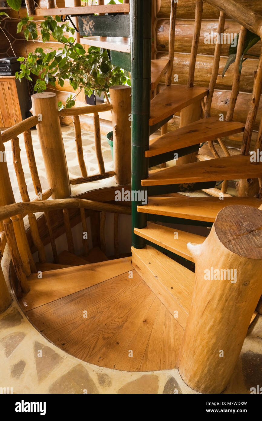 Spiral shaped staircase inside a rustic cottage style residential log ...