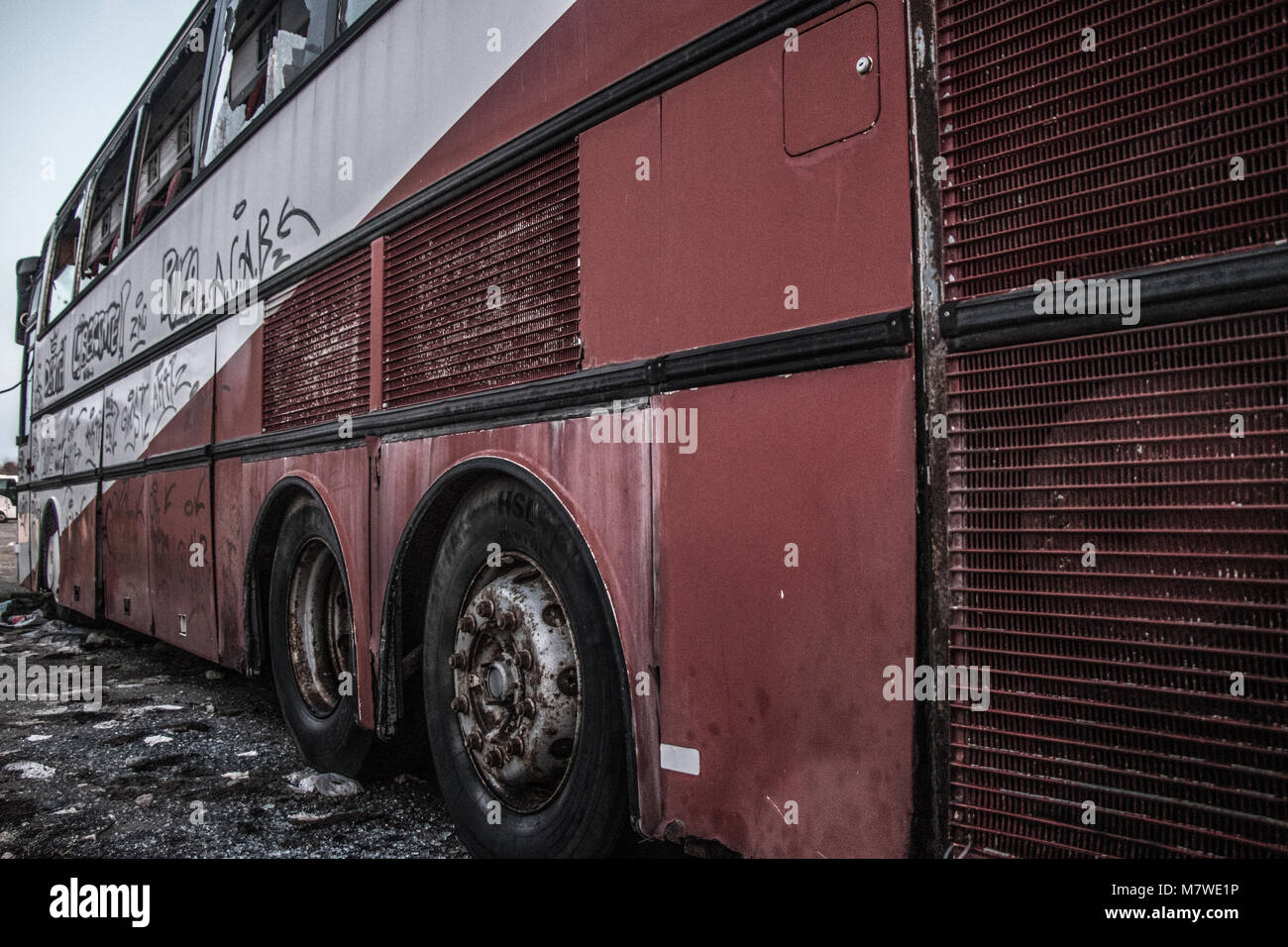 Rusty abandoned long bus scene Stock Photo - Alamy