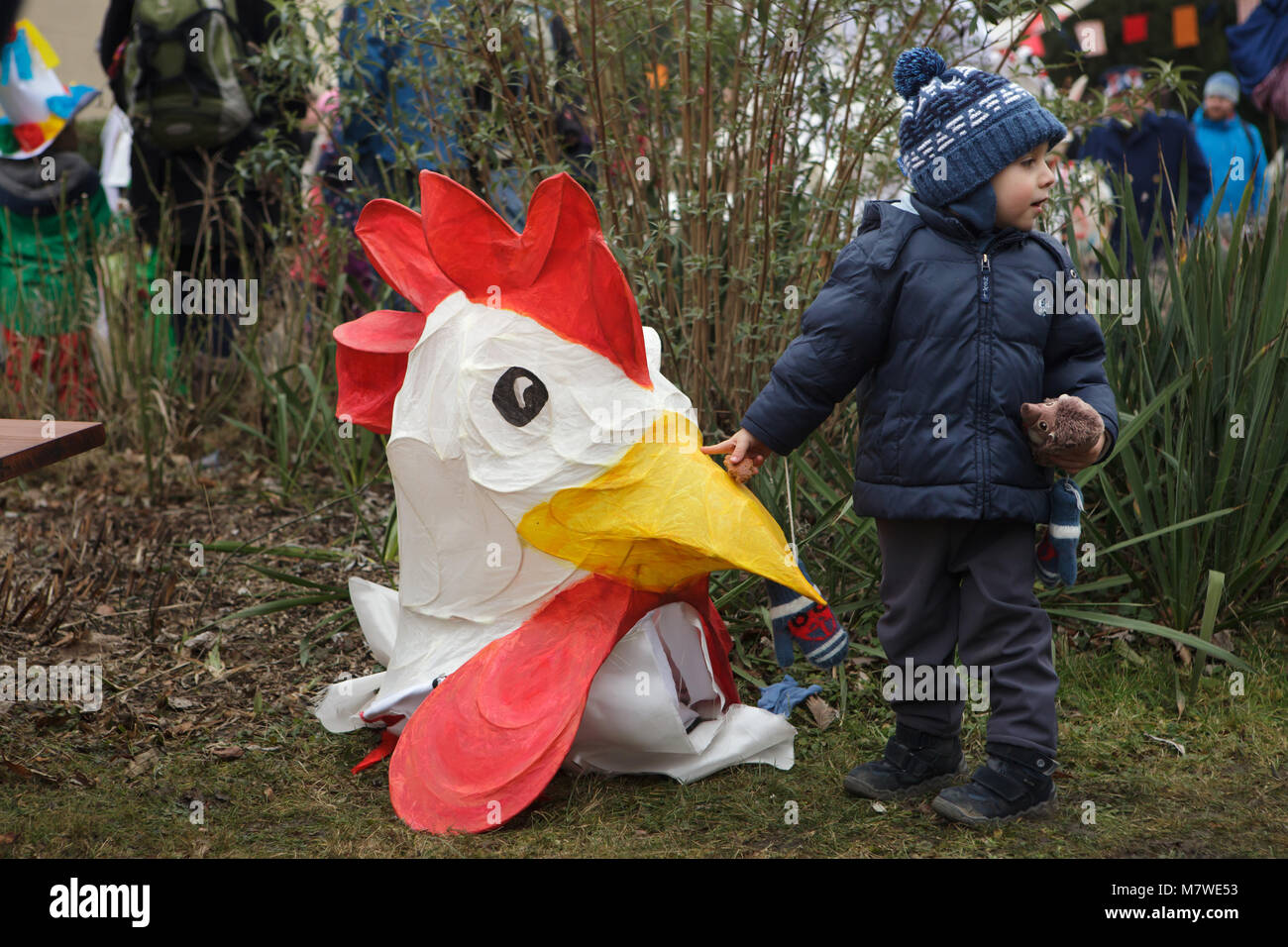 Young boy touches the huge mask of the Rooster during the Roztocký ...
