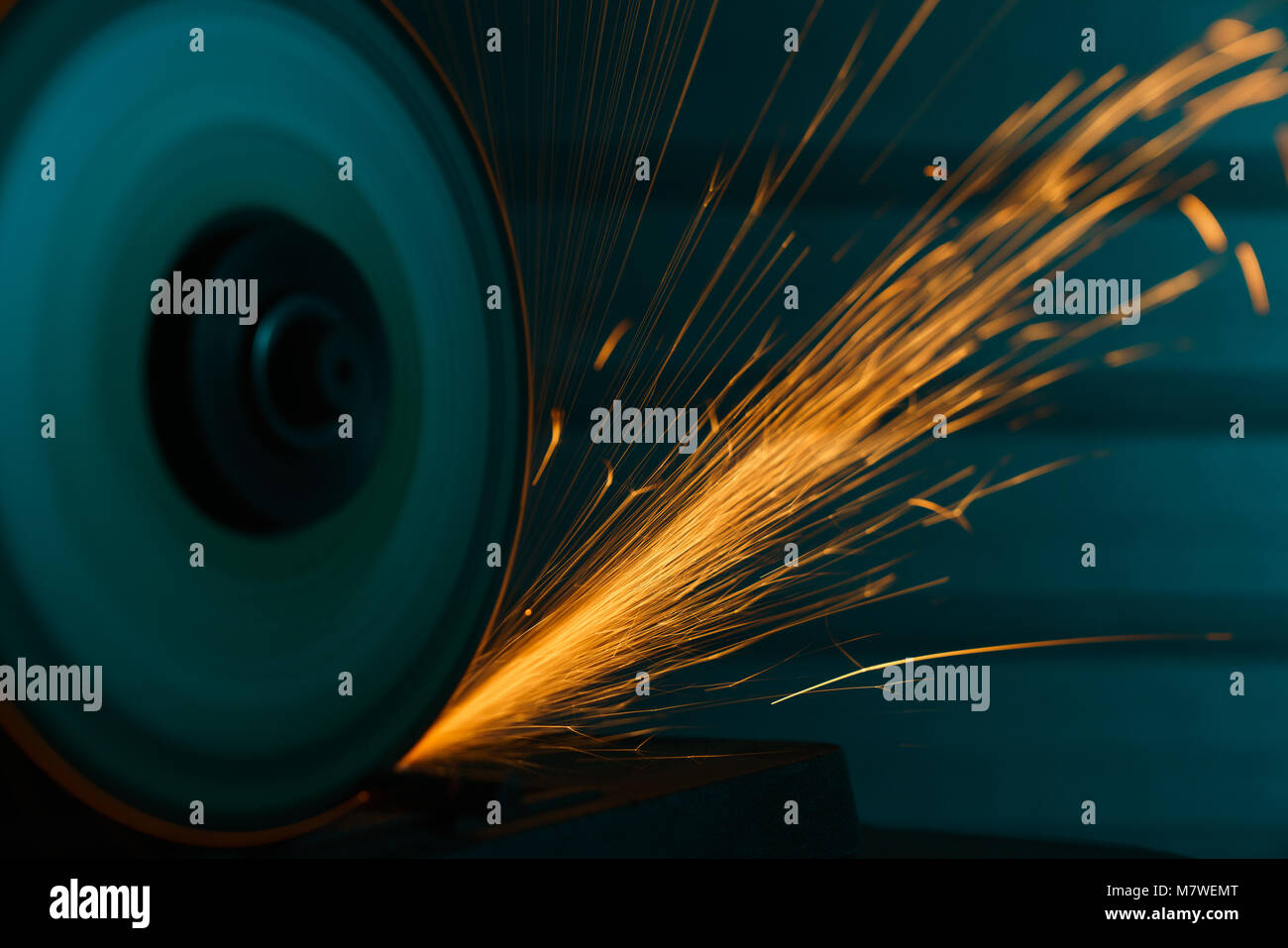 Close-up shot of an angle grinder with sparkles over metal background ...