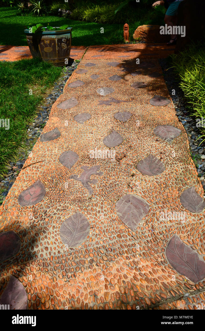 A pathway made from cobblestones, interspersed with manufactured paving ...