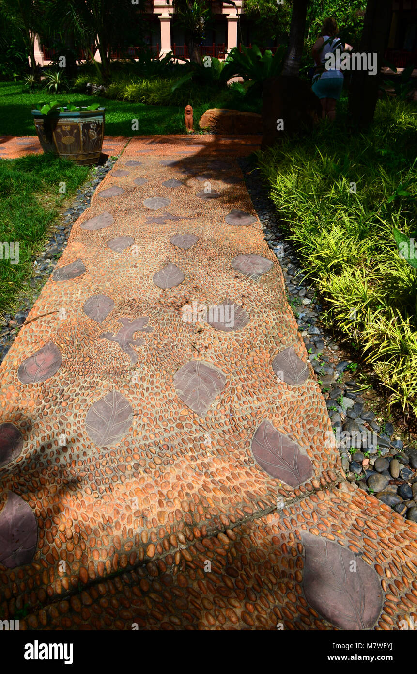 A pathway made from cobblestones, interspersed with manufactured paving ...