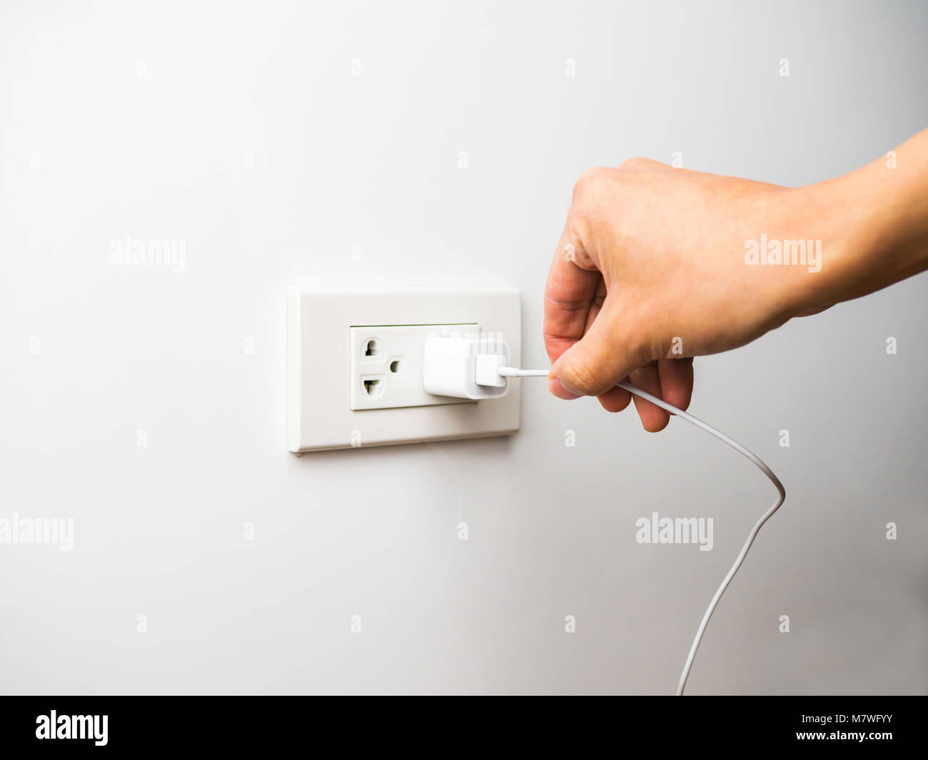 Unplug by pulling wire and cord from socket Stock Photo - Alamy