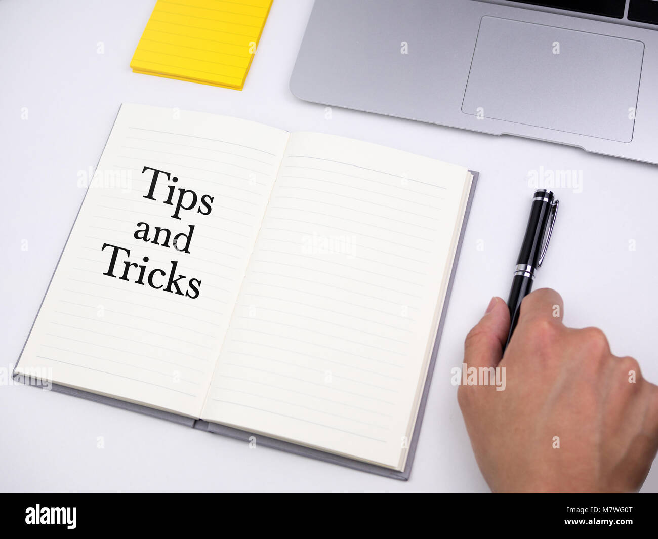 Tips and tricks on note book with hand on desk Stock Photo - Alamy