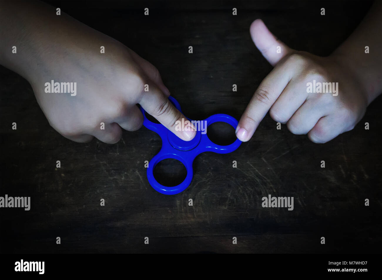 Hand holding fidget spinner Stock Photo - Alamy
