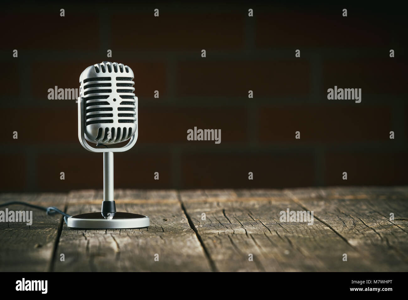 Silver vintage microphone on old wooden table Stock Photo - Alamy
