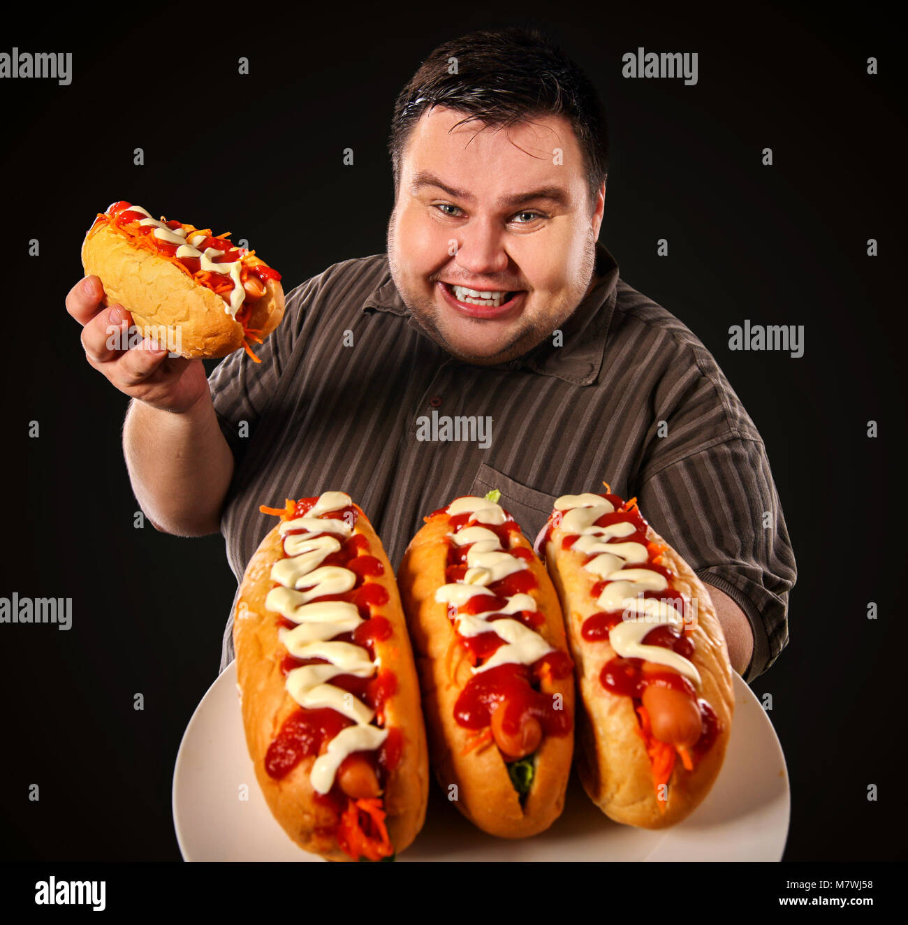 Fat man eating fast food hot dog. Breakfast for overweight person Stock ...