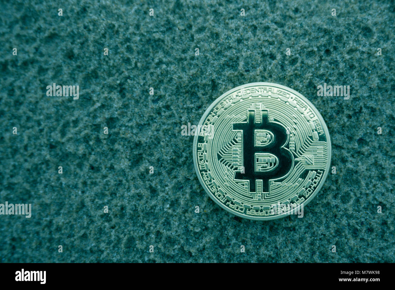 Golden bitcoin coin in the sand Stock Photo - Alamy