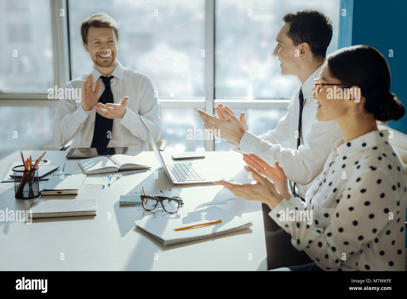 Upbeat colleagues clapping hands during meeting in office Stock Photo ...