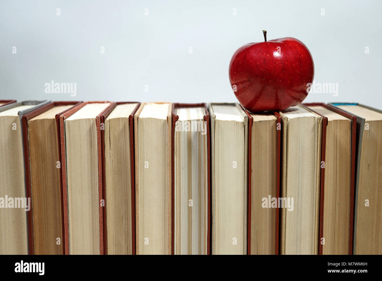 Stack of books and apple on the table Stock Photo - Alamy