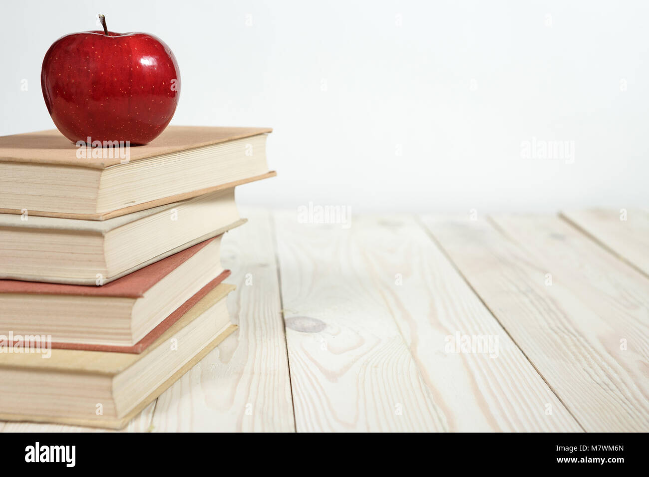 Stack of books and apple on the table Stock Photo - Alamy