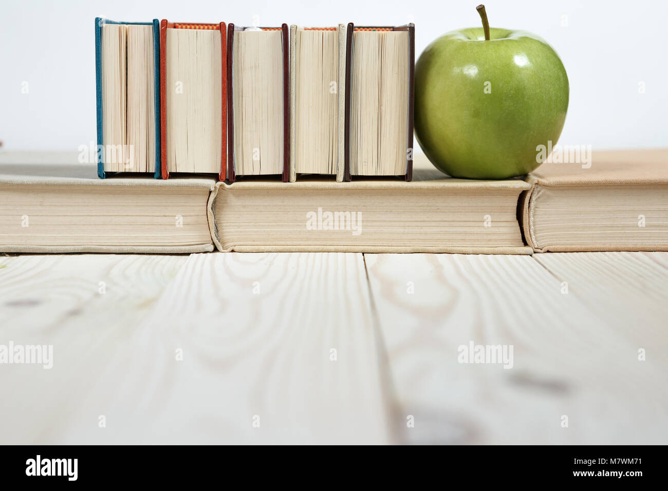 Stack of books and apple on the table Stock Photo - Alamy