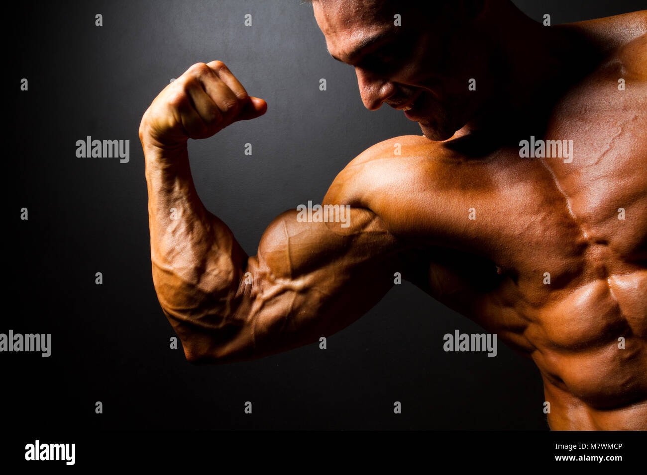 strong bodybuilder posing on black background Stock Photo - Alamy