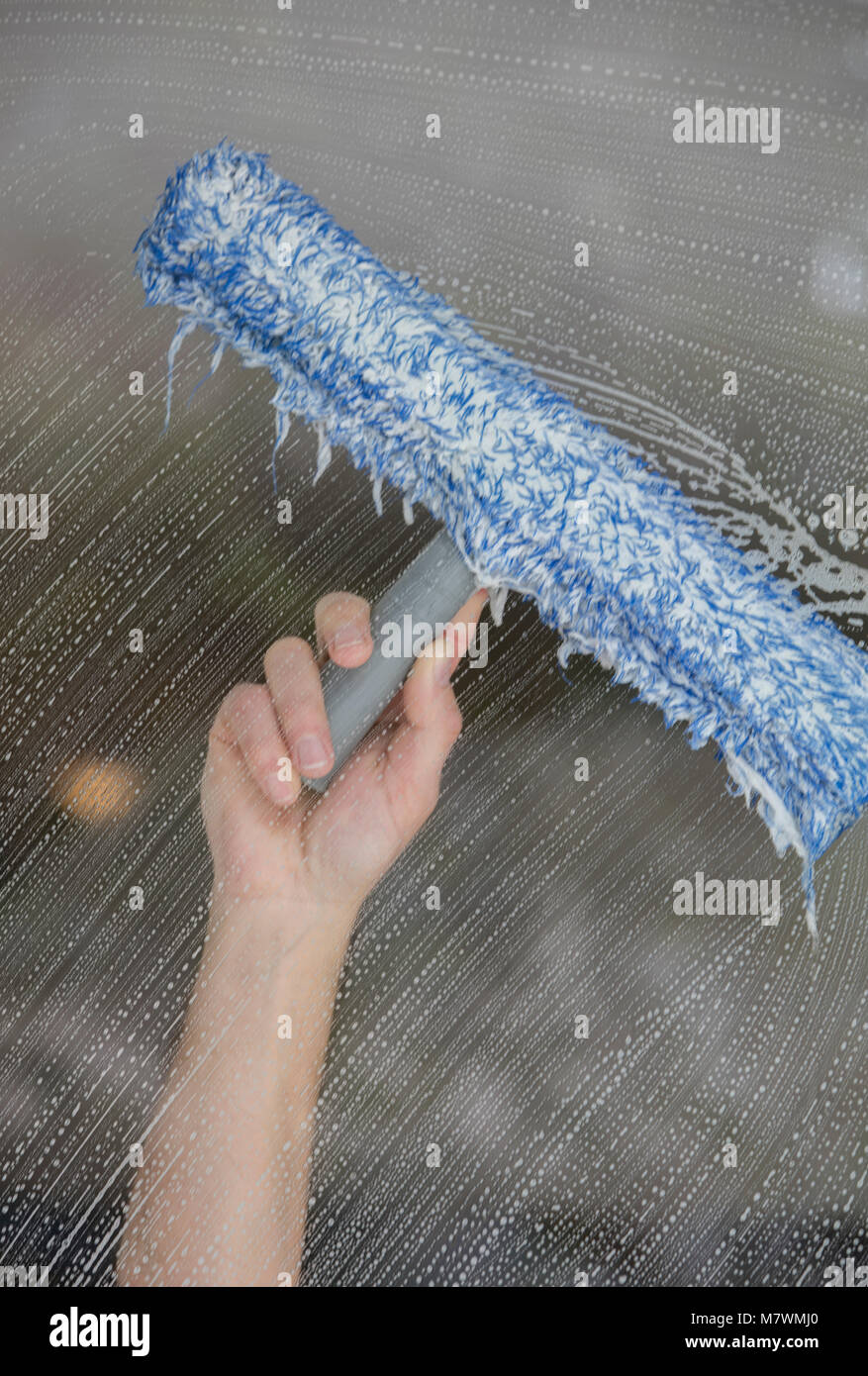 a soapy window with a squeegee cleaning the glass Stock Photo - Alamy