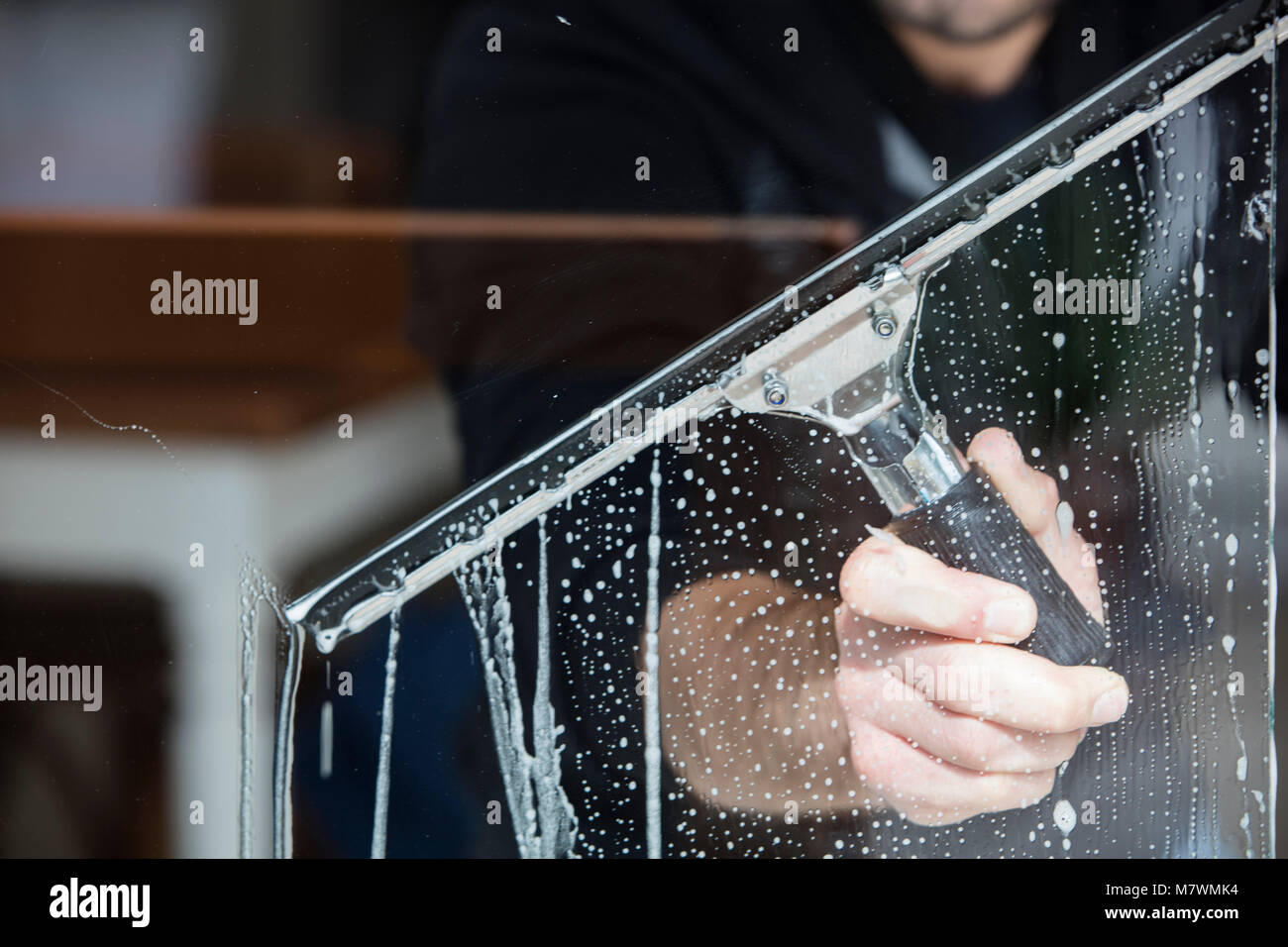 a soapy window with a squeegee cleaning the glass Stock Photo - Alamy