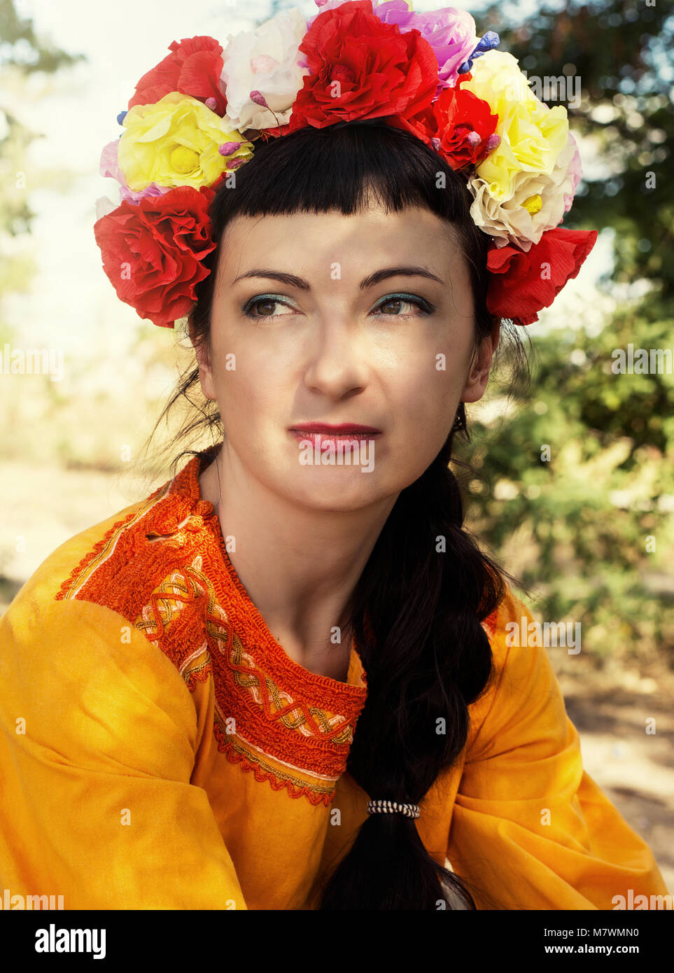 charming woman in wreath of roses on her head on the background of ...