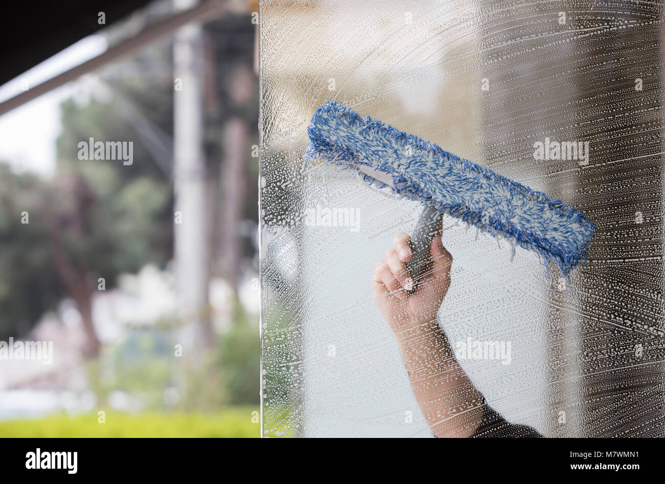 a soapy window with a squeegee cleaning the glass Stock Photo - Alamy