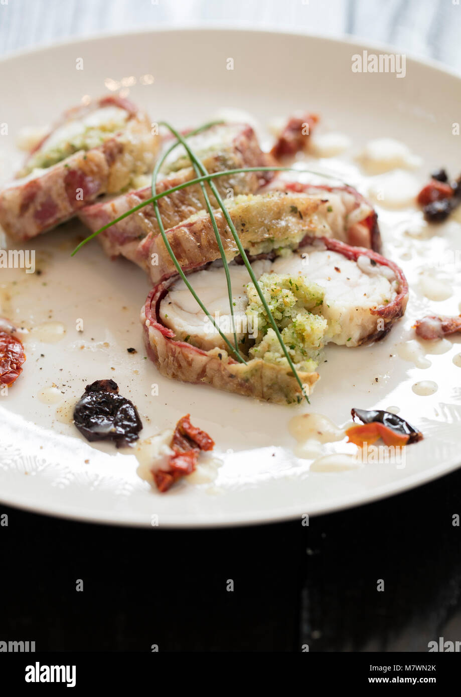 cod fish wrapped in bacon on black background Stock Photo - Alamy