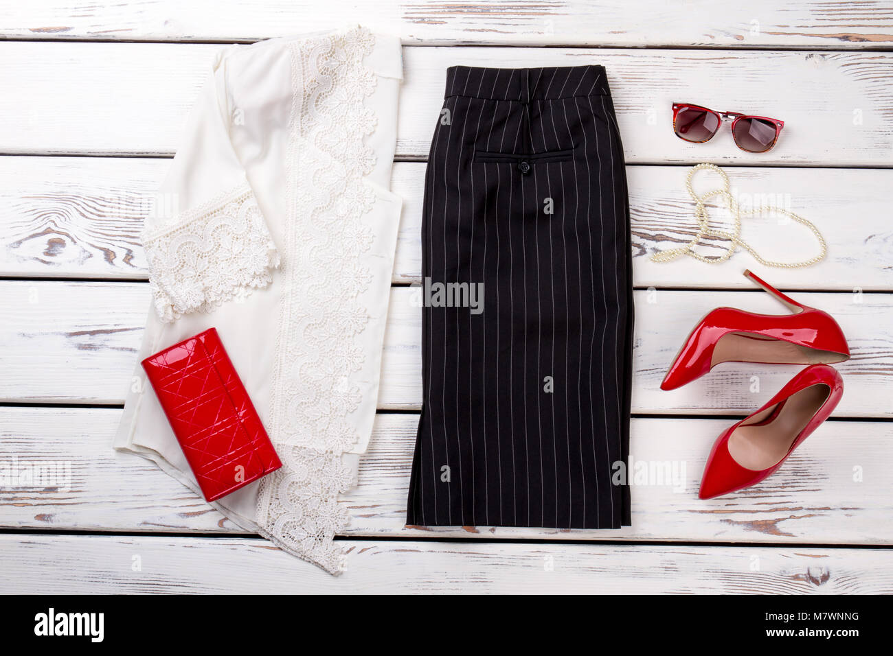 Woman's accessories flat lay on white wood background. Folded white ...