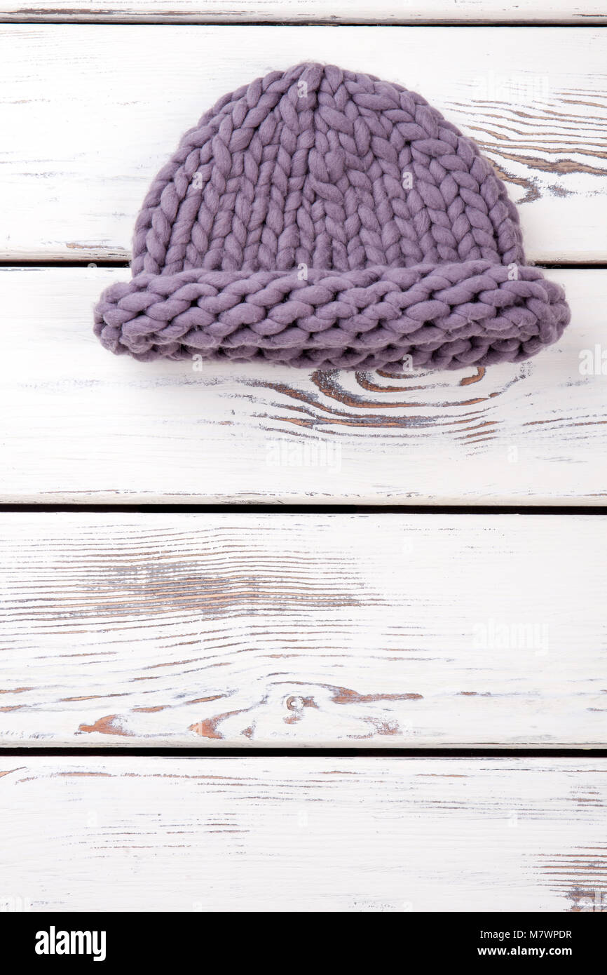 Flat lay purple knitted hat. White wooden desks surface background ...