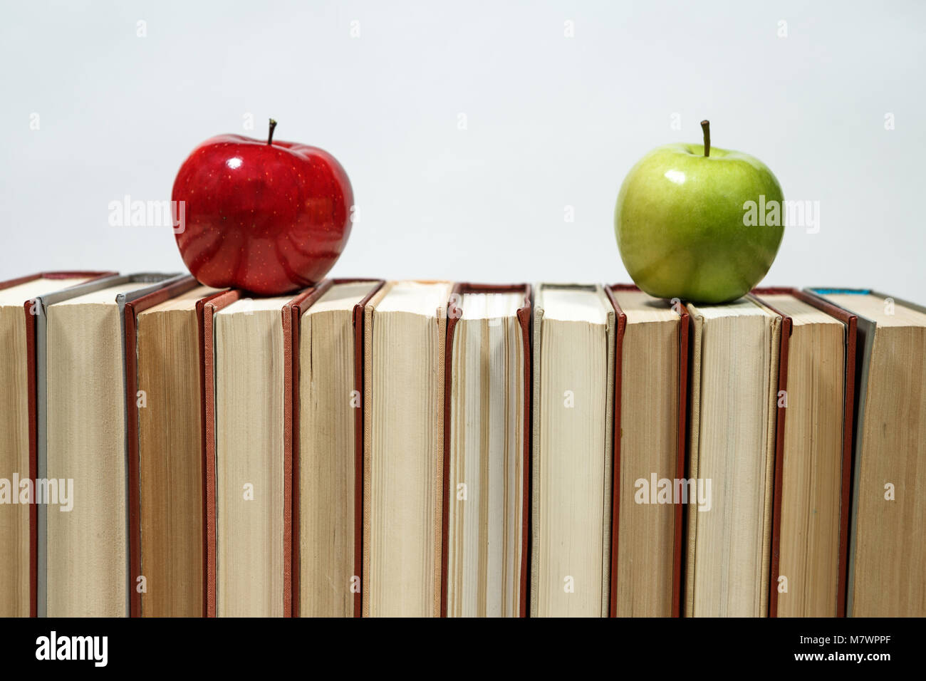 Stack of books and apple on the table Stock Photo - Alamy