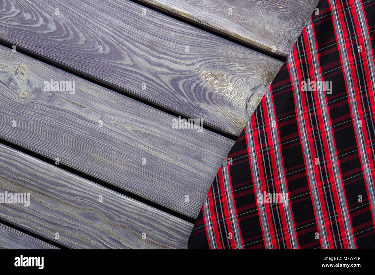 Extreme close up checkered clothes material. Grey wooden surface ...