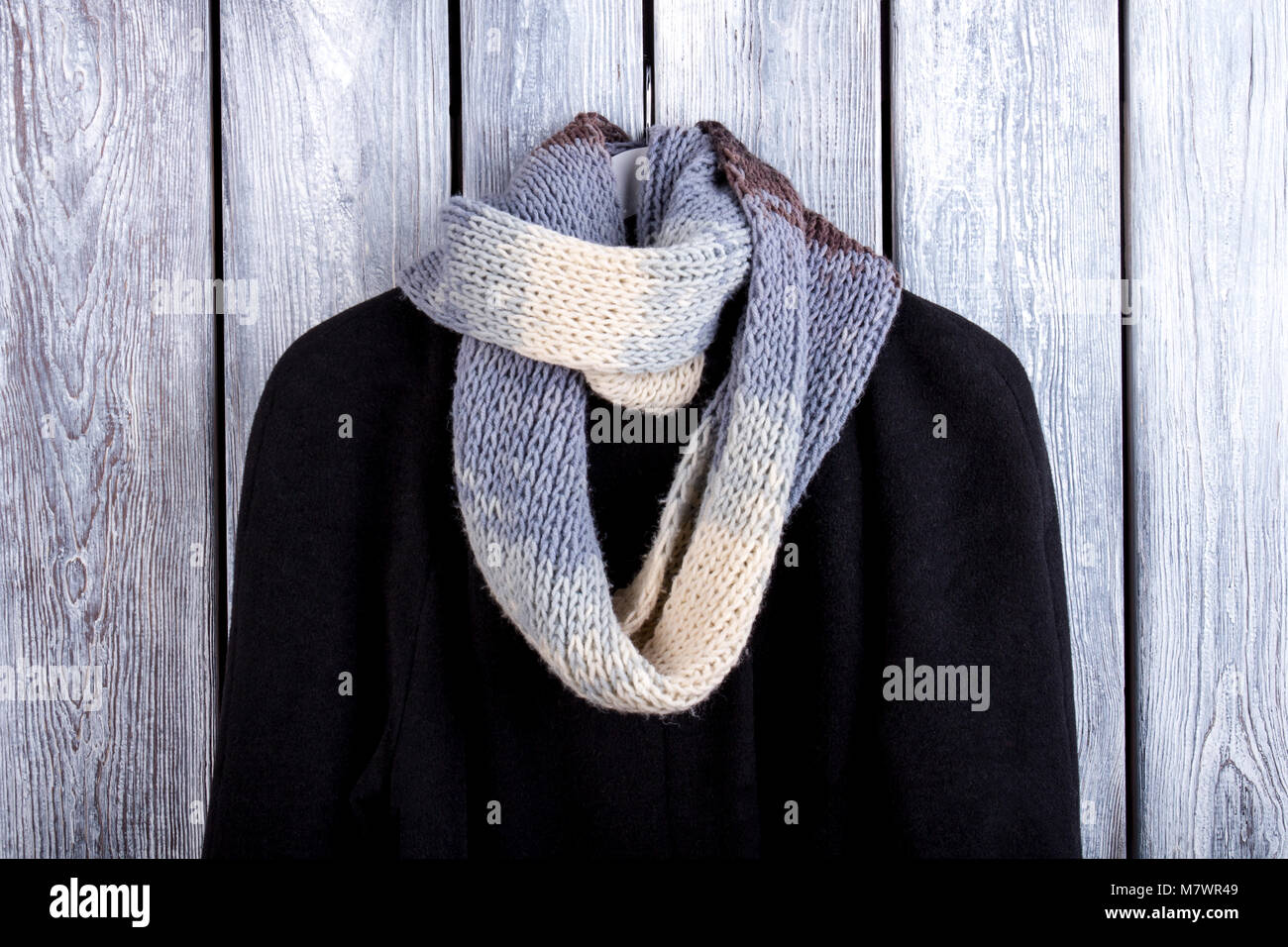 Warm wool scarf and black coat. Wooden desk surface background Stock ...