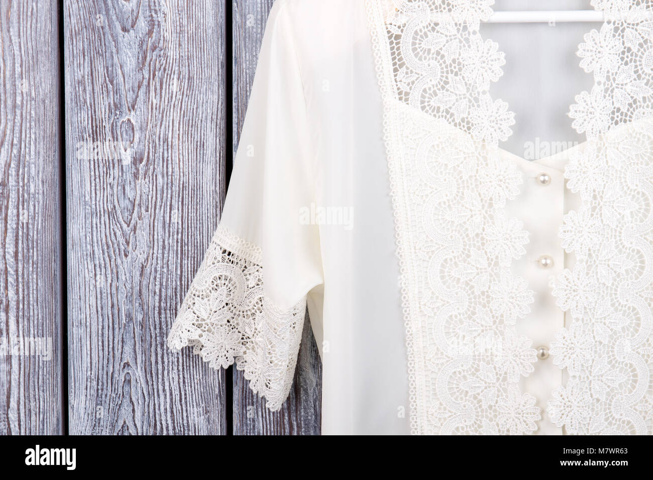 Extreme close up white lace clothing. Front view. Dark wooden surface ...