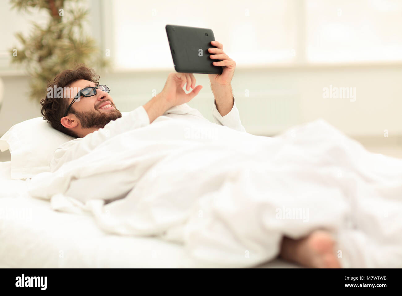 closeup.sleepy man looking at the screen of a digital tablet Stock ...