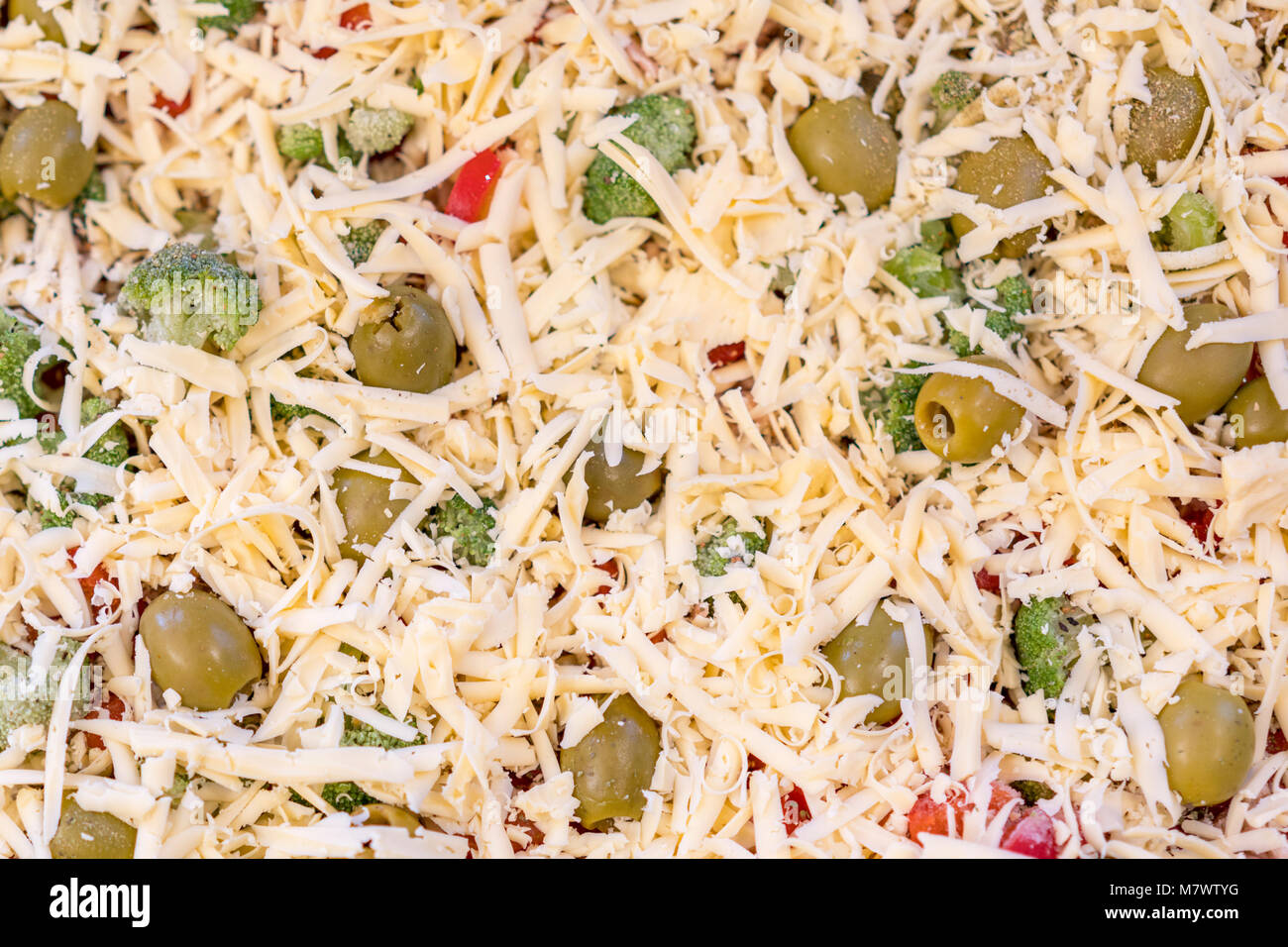 Pizza before baking. Background of grated cheese Stock Photo - Alamy