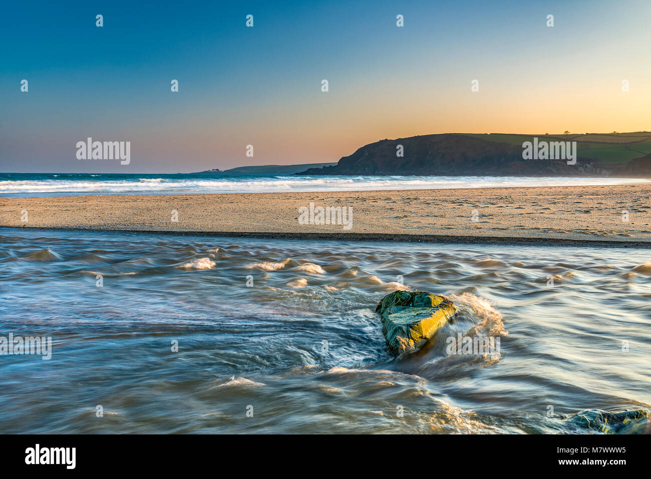 Sun Blushed Rocks Rest Against a Rivers Final Journey Stock Photo - Alamy
