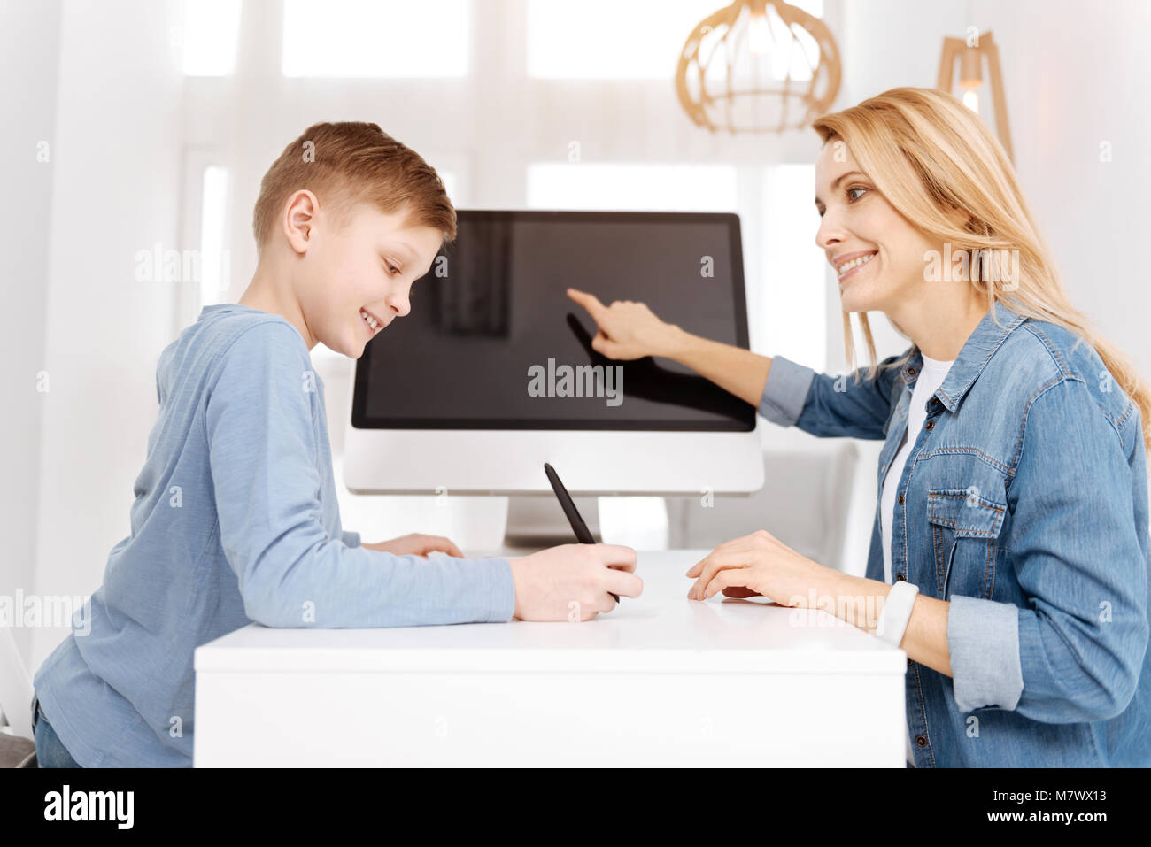 Delighted positive woman pointing at the monitor Stock Photo - Alamy