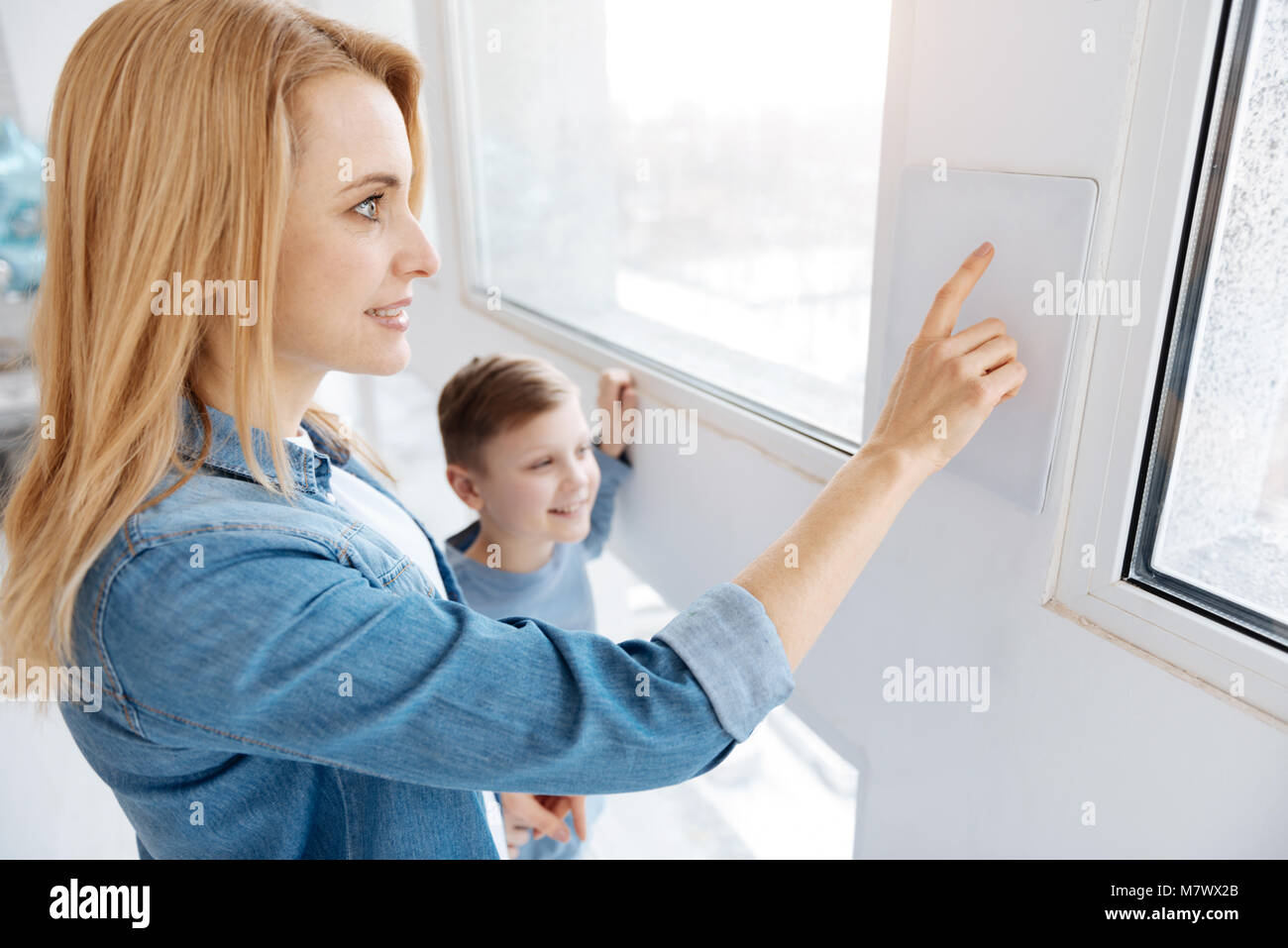 Delighted positive woman using the control panel Stock Photo - Alamy
