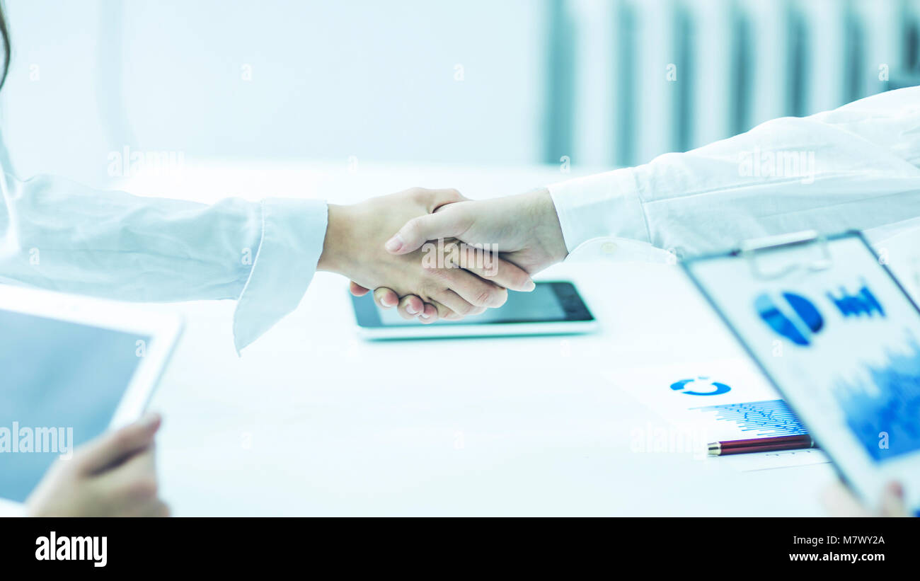 handshake Manager and client on a background of bright office .the ...